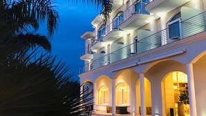 Um hotel com várias andares, varandas e passagens em arco.