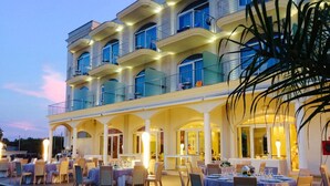 Um hotel com vários andares, áreas de refeições ao ar livre e varandas.