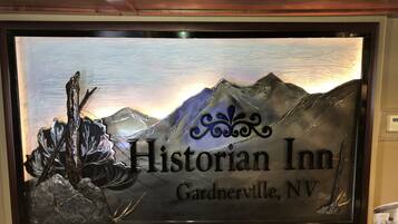 Placa emoldurada do Historian Inn em Gardnerville, Nevada, com paisagem de montanhas e detalhes decorativos.