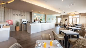 Um restaurante moderno com área de bar, piso de madeira e móveis de vime.