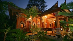 Um edifício tradicional com varanda coberta, colunas e área de estar.