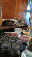 Um buffet de café da manhã com diversas opções de comida e bebidas.