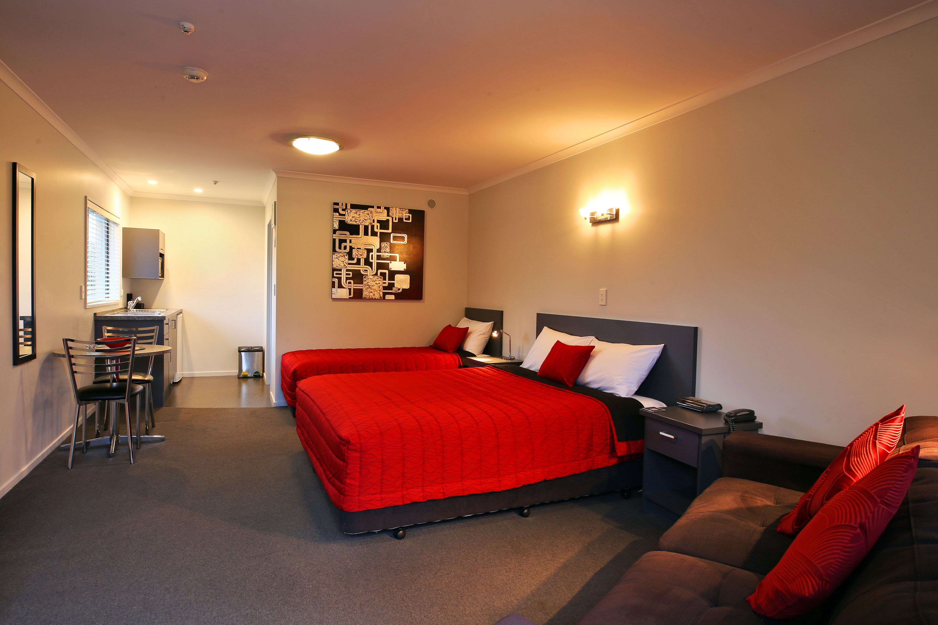 Quarto de hotel com uma cama grande, uma escrivaninha e uma cadeira.