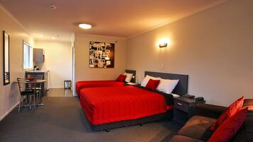 Quarto de hotel com uma cama grande, uma escrivaninha e uma cadeira.