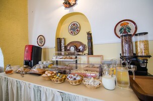 Um buffet de café da manhã com diversas opções de comida e uma máquina de café.