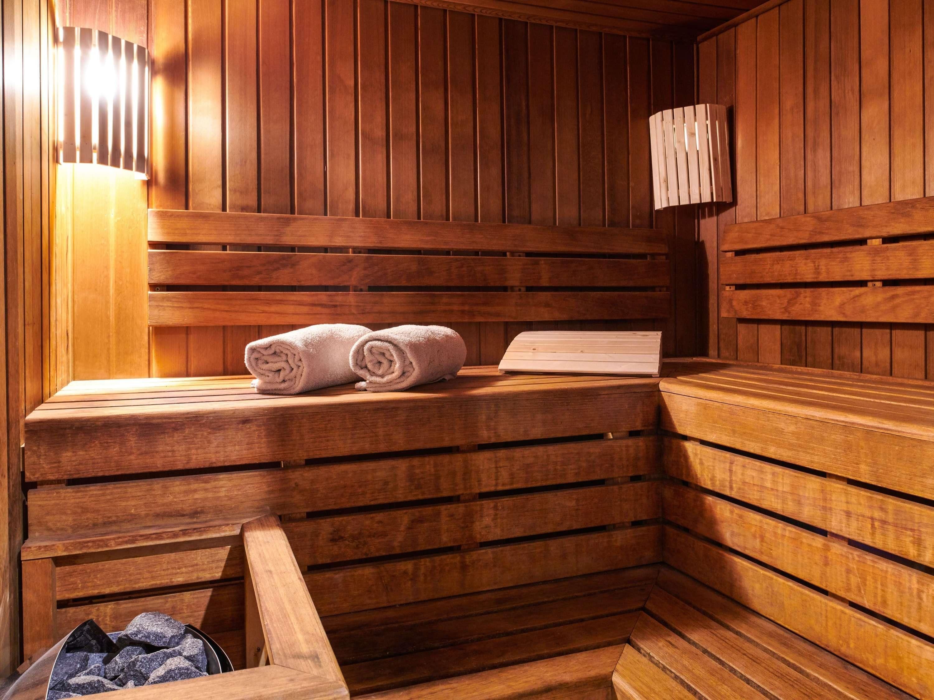 Uma sauna com bancos de madeira, toalhas e um banco com uma toalha.