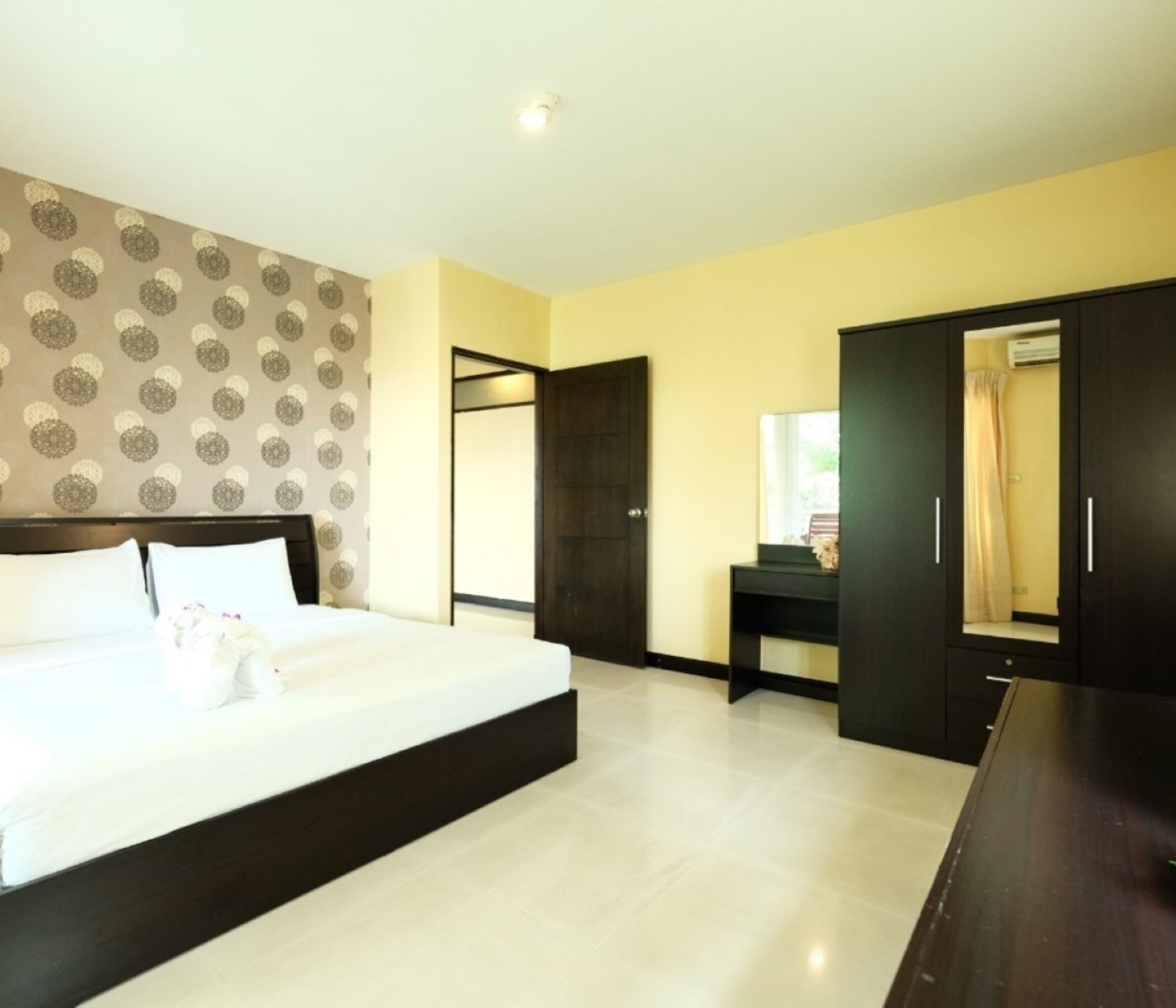 Quarto de hotel moderno com uma cama grande, uma escrivaninha e um guarda-roupa.
