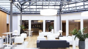 Amplo espaço interno com teto alto, móveis modernos e um bar.