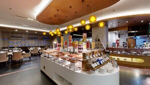Uma área de buffet com diversos alimentos e um espaço para café.