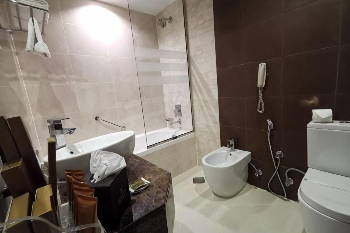 Casa de banho moderna com banheira, bidé, sanita e toucador com espelho.