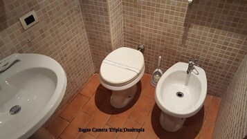 Casa de banho com sanita, bidé e lavatório.