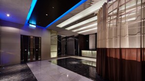 Um hall amplo com piso de mármore, balcão de recepção e design de teto moderno.