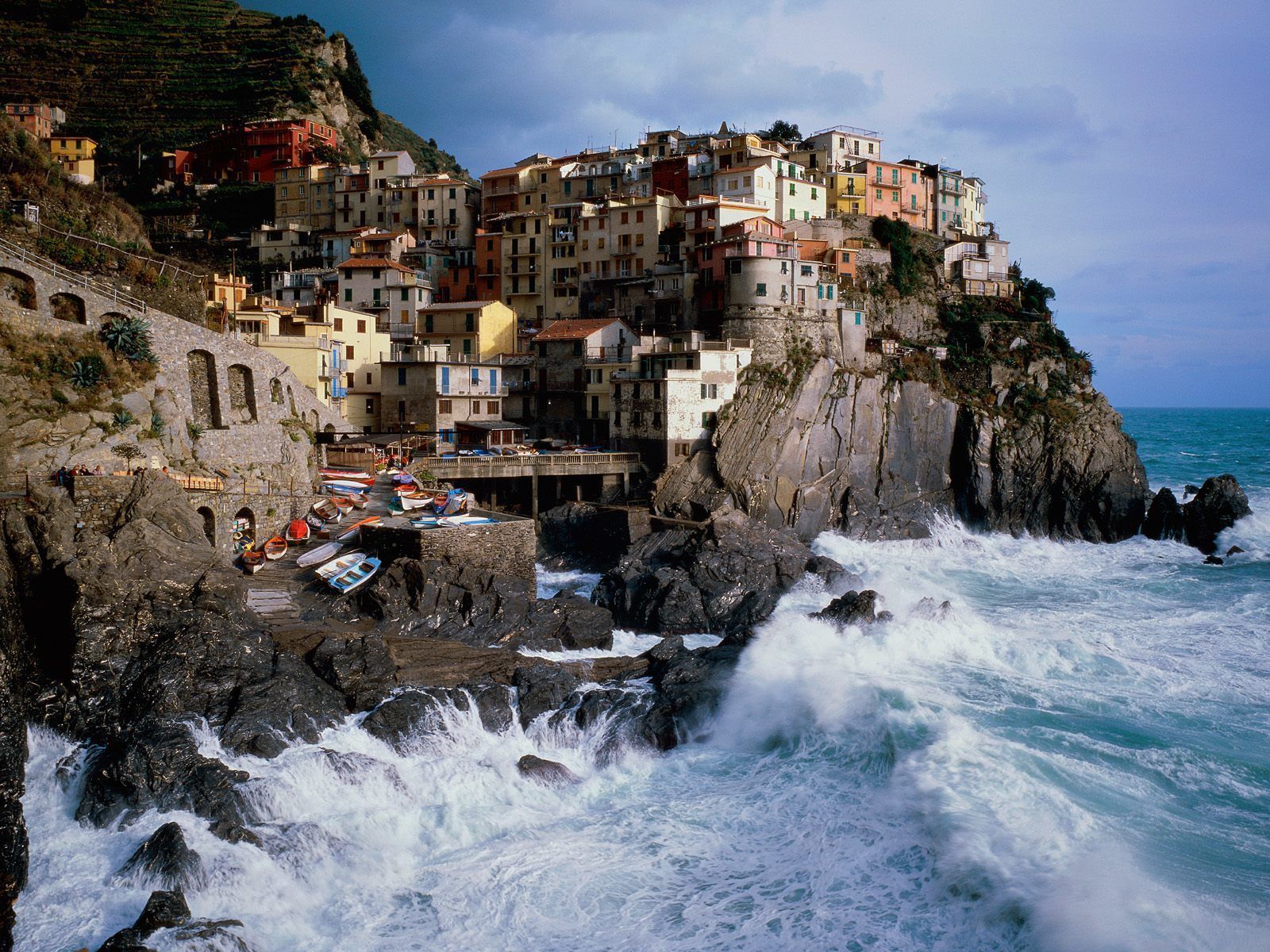 Uma vila costeira com edifícios construídos em um penhasco com vista para o mar.