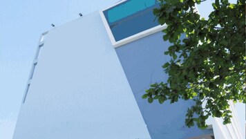 Um edifício com fachada branca e janela azul.