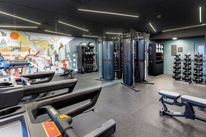 Uma academia moderna com diversos equipamentos de exercício, incluindo esteiras, aparelhos de musculação e pesos livres.