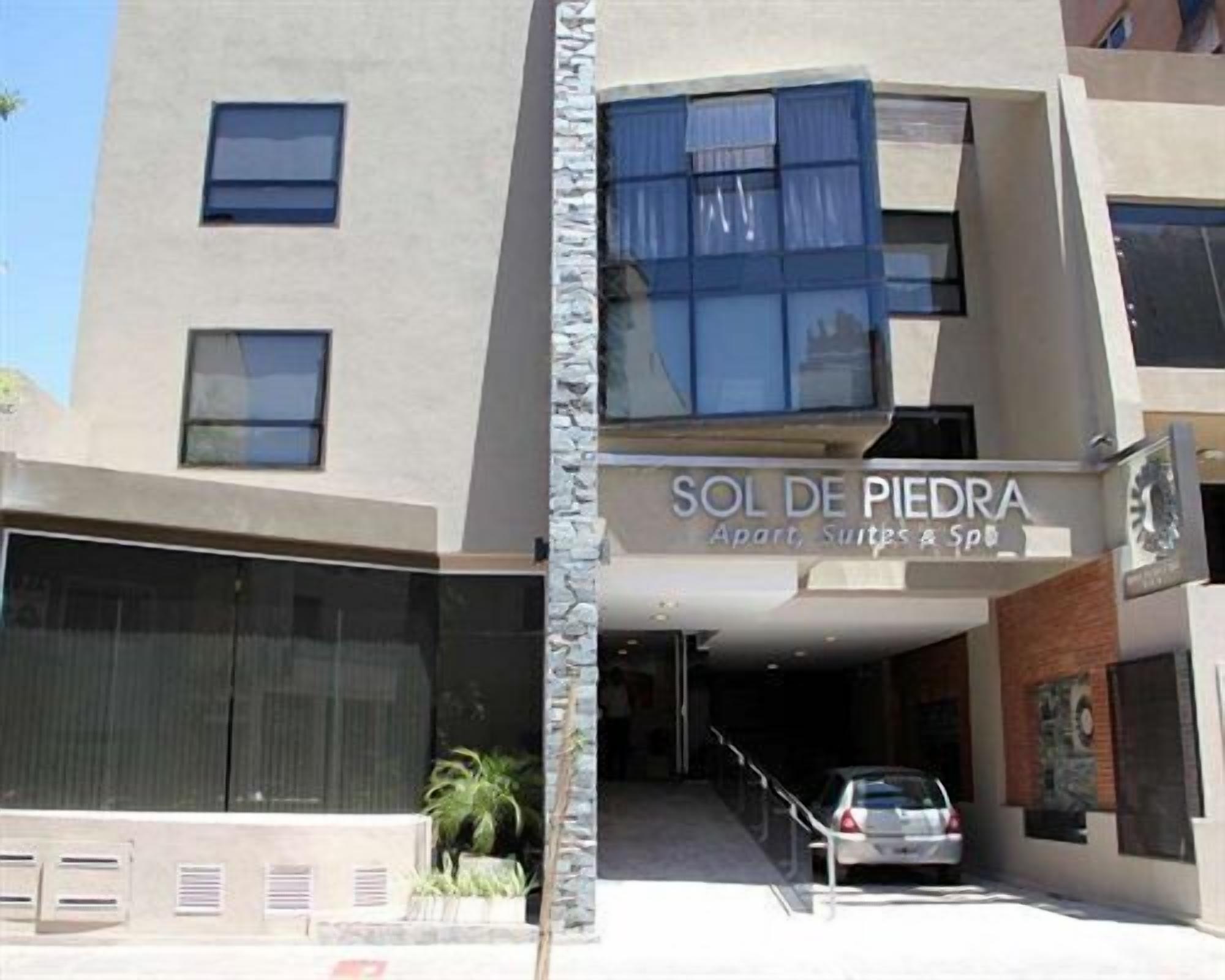 Um edifício com uma placa que diz "SOL DE PIEDRA Apart, Suites & Spa".