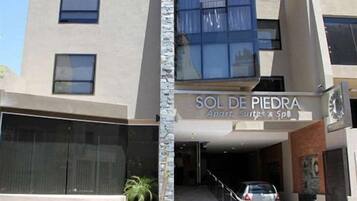 Um edifício com uma placa que diz "SOL DE PIEDRA Apart, Suites & Spa".