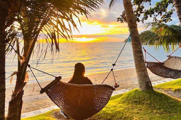 Na praia, espreguiçadeiras, toalhas de praia, massagens na praia