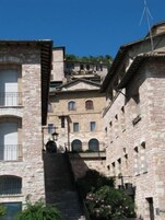 Um edifício de pedra com várias varandas e uma escadaria que leva a um andar superior.