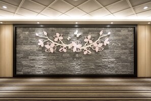 Parede com design floral e fundo de pedra texturizada.