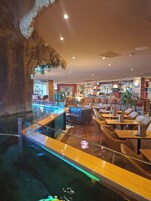 Uma área de bar com assentos e piscina.