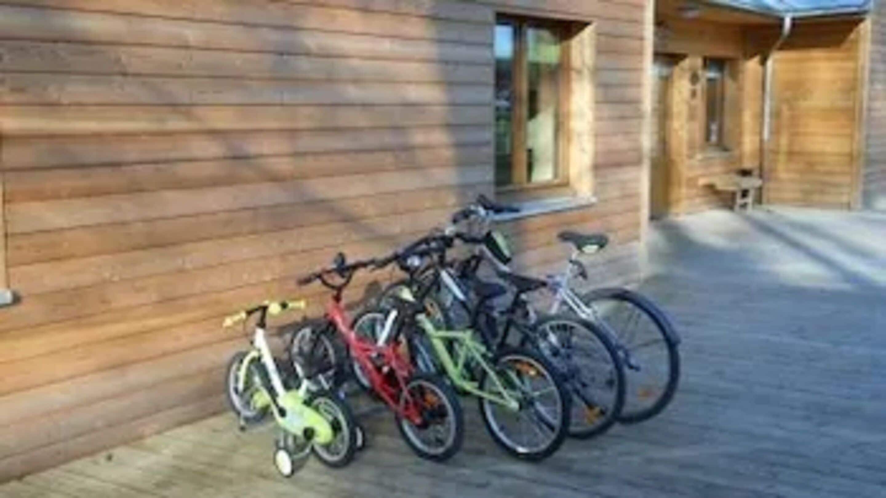 Um edifício de madeira com bicicletas estacionadas na frente.