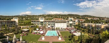 Um hotel com piscina, área de estar externa e vista para as colinas ao redor.
