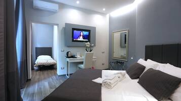 Quarto de hotel moderno com uma cama grande, uma escrivaninha, televisão de tela plana e um espelho.
