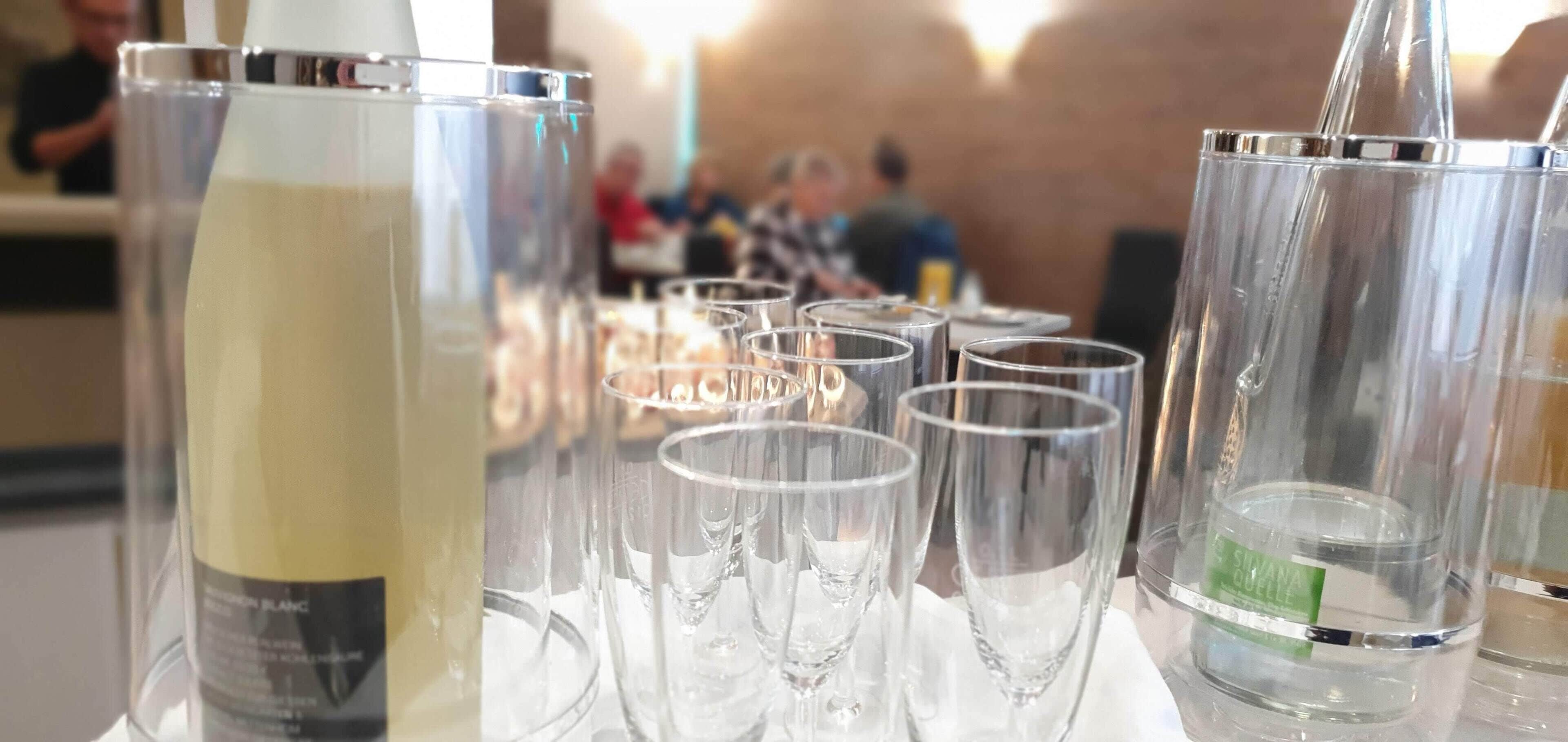 Uma mesa com vários copos e garrafas, provavelmente para bebidas.