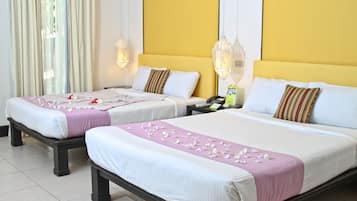 Duas camas de casal com lençóis brancos, colchas rosa e pétalas de flores decorativas.