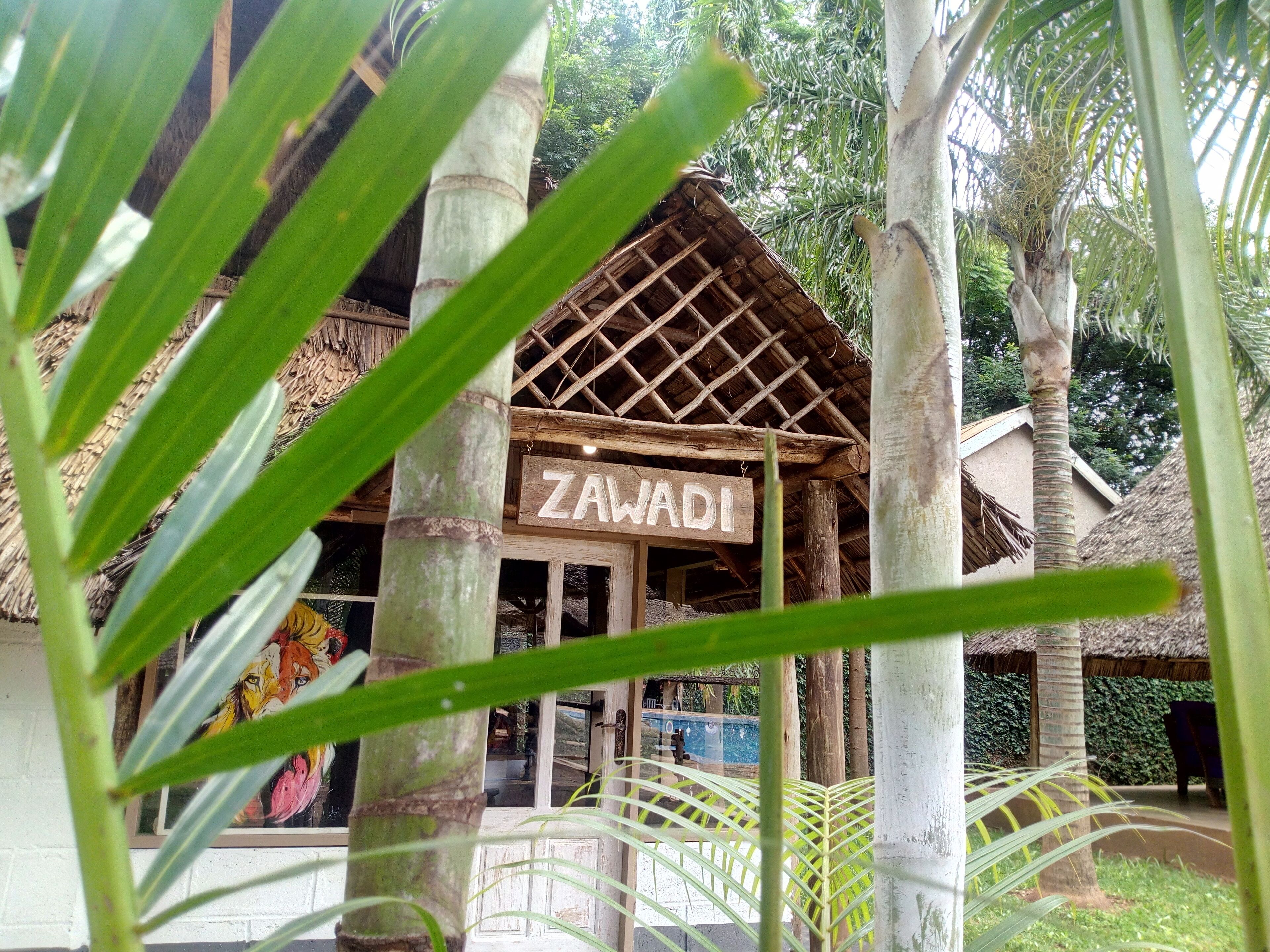Um edifício rústico com uma placa que diz "ZAWADI".