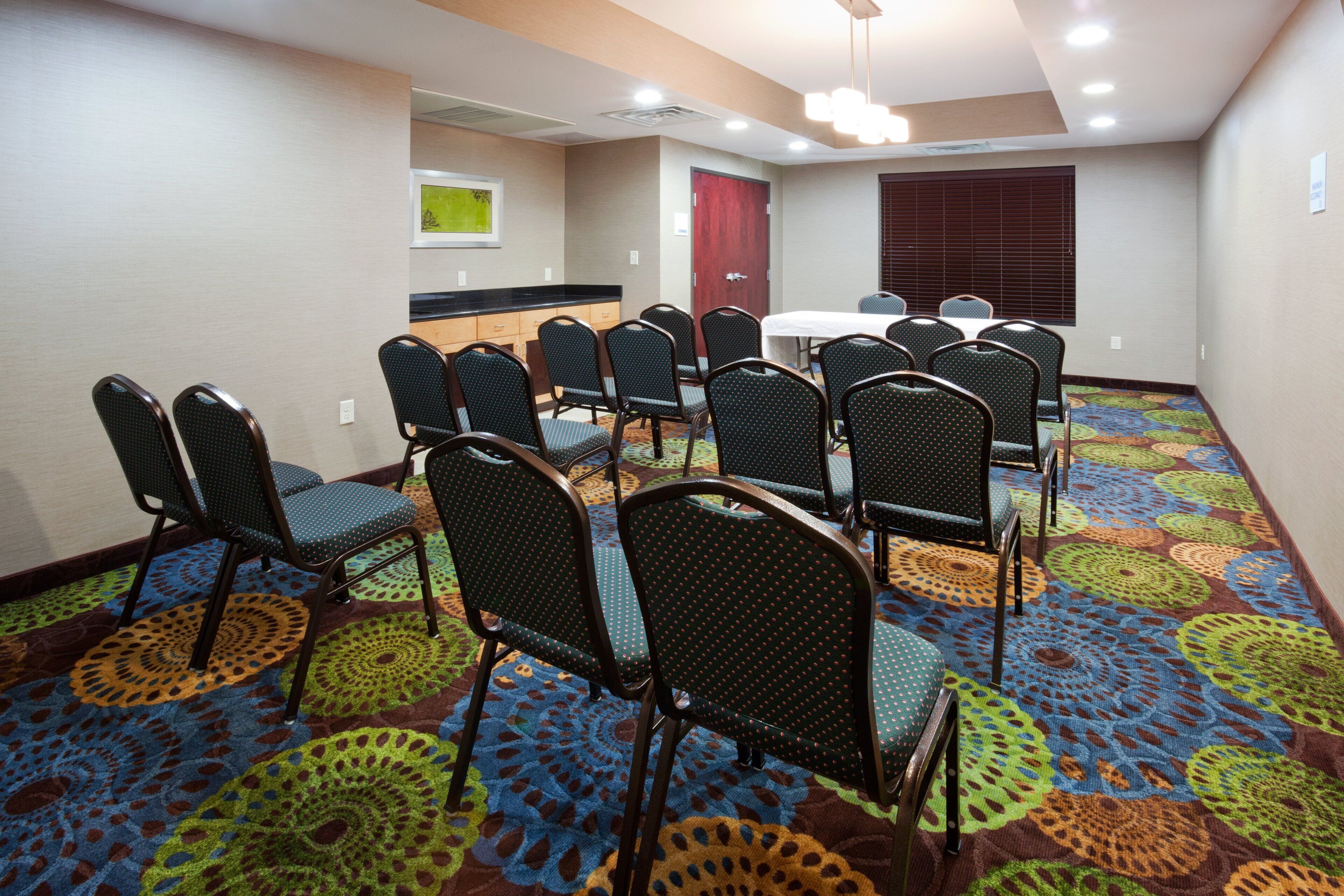 Sala de conferências com mesa e cadeiras dispostas para reuniões.