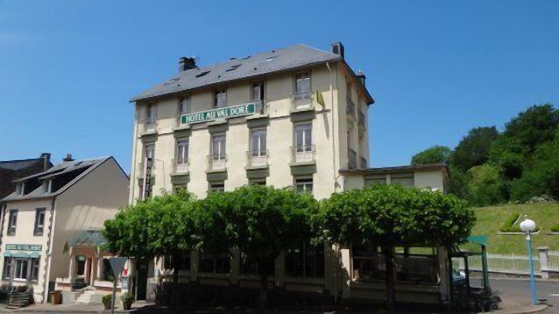 Um hotel de vários andares com uma placa que diz 'HOTEL AU PERE'.