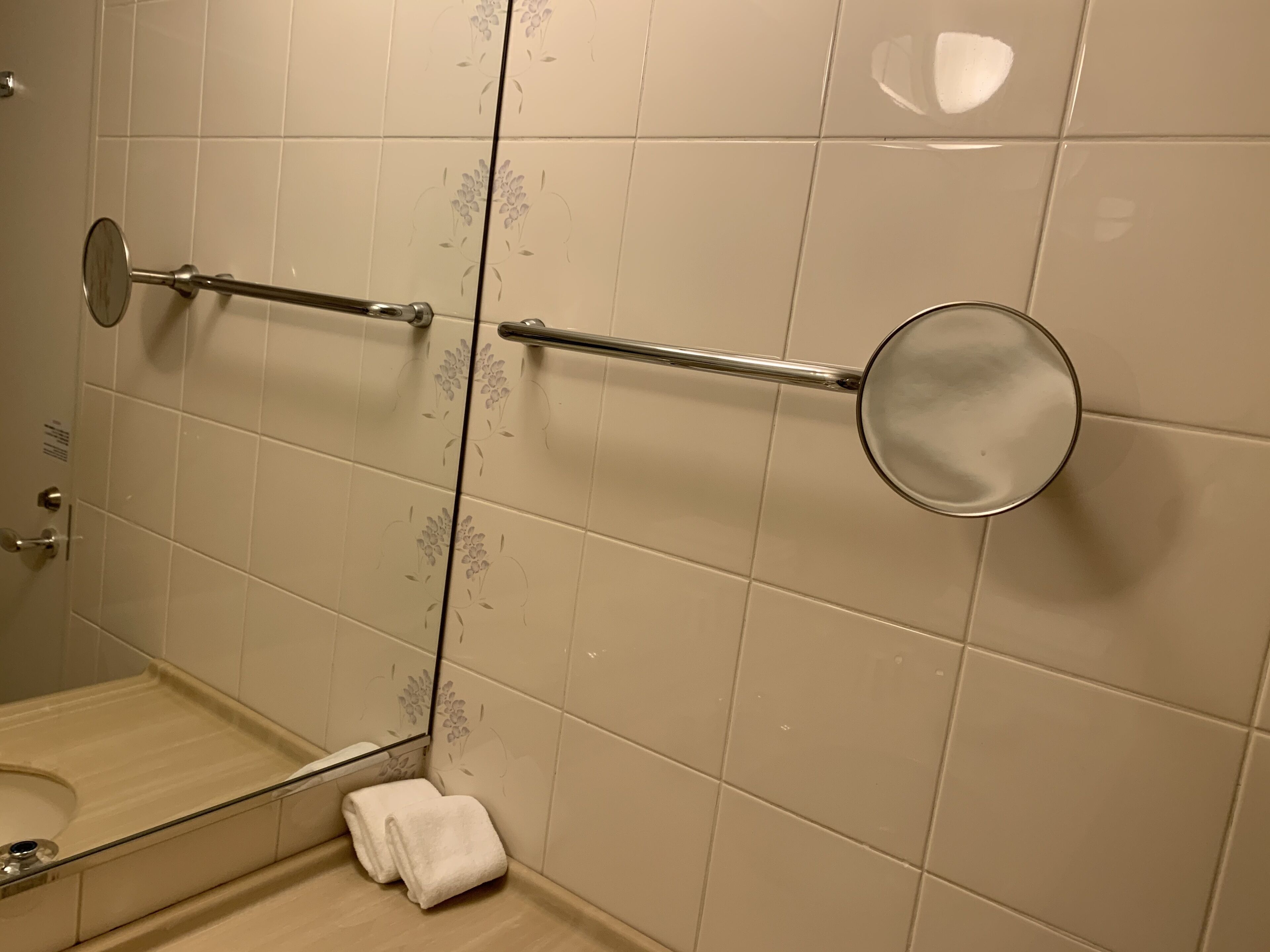 Casa de banho com sanita, secador de mãos, para-toalhas e espelho.