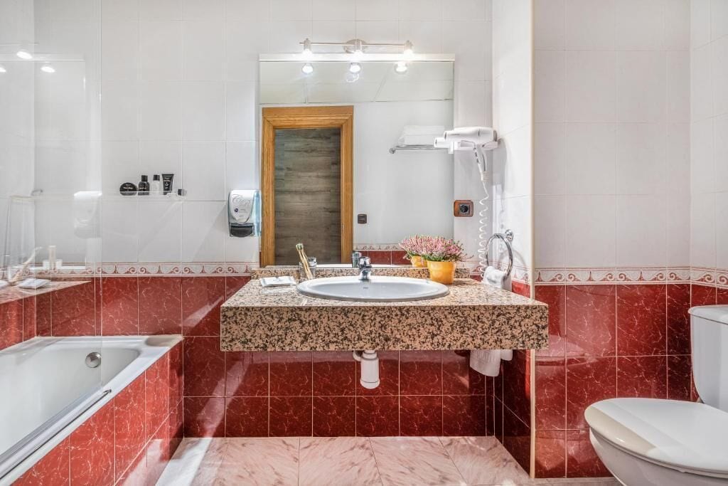 Uma casa de banho com lavatório de mármore, banheira e sanita.