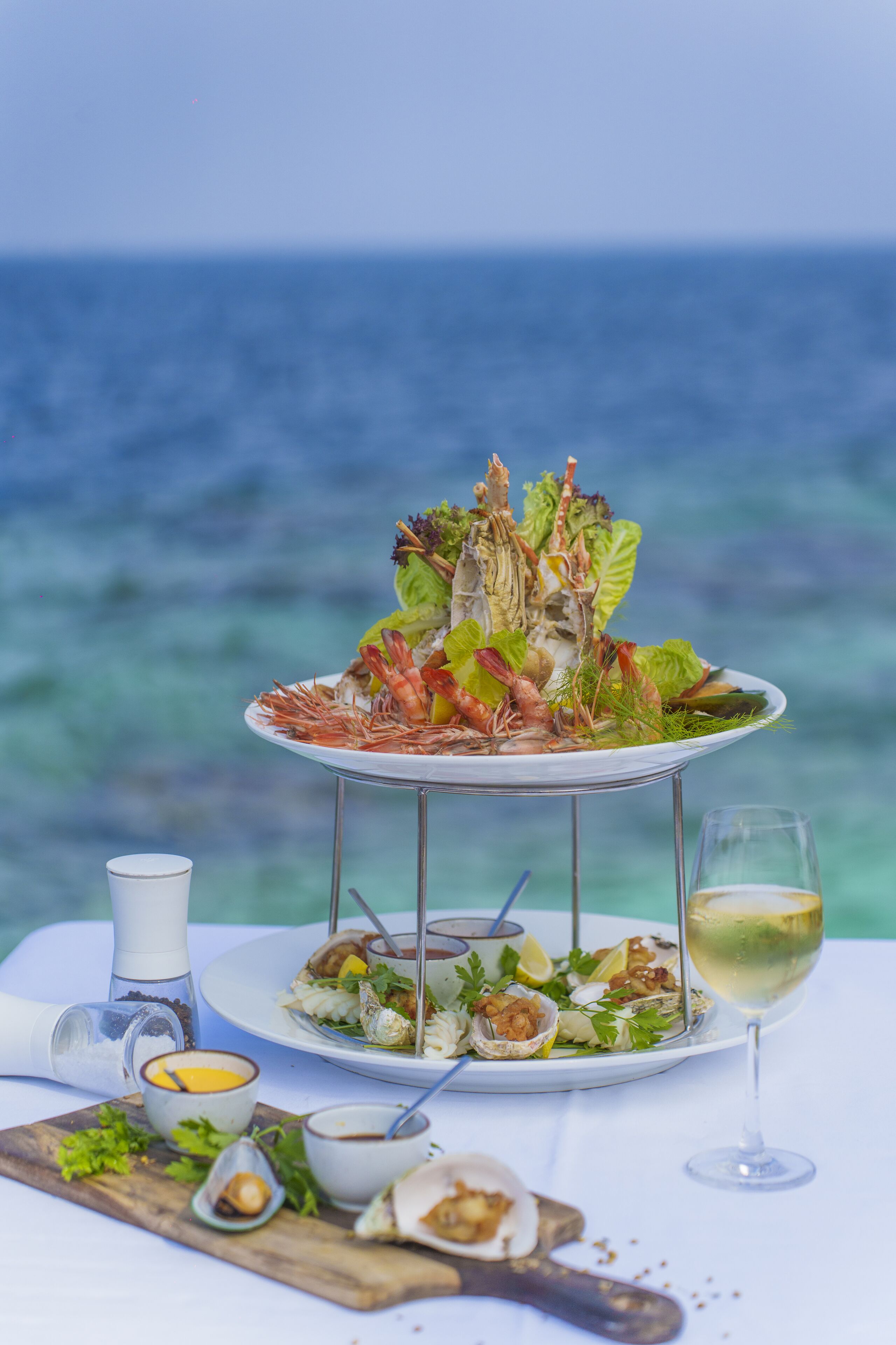 Uma seleção de frutos do mar numa mesa com vista para o oceano.