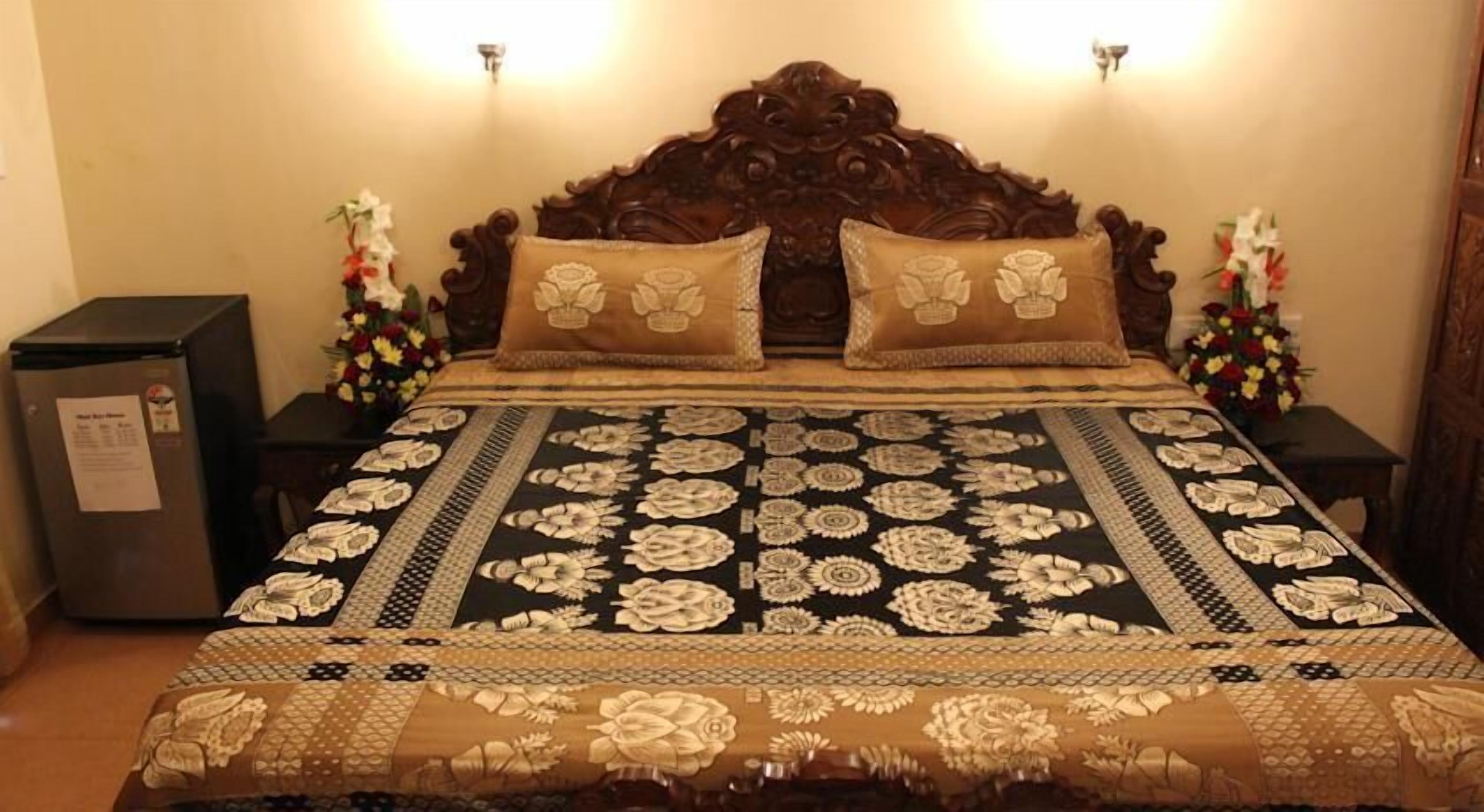 Uma cama com colcha estampada com flores, duas almofadas iguais e cabeceira de madeira.