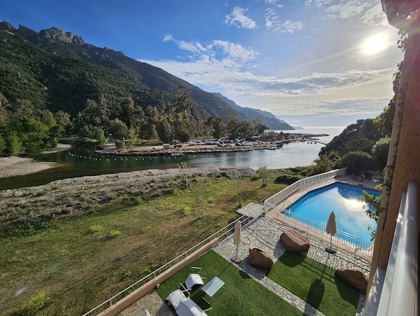 Uma piscina com vista para um rio e montanhas.