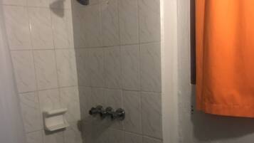 Casa de banho com chuveiro, sanita e porta-toalhas.