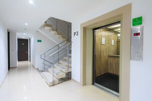 Interior moderno com escada, elevador e uma placa indicando o local como P3.