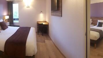 Quarto de hotel com uma cama grande, mesas de cabeceira, uma pequena escrivaninha e um espelho.