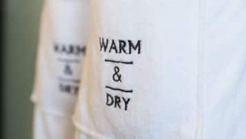 Close-up de uma toalha branca com os dizeres 'WARM & DRY' bordados.