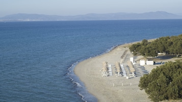 Na praia, espreguiçadeiras, guarda-sóis de praia, toalhas de praia