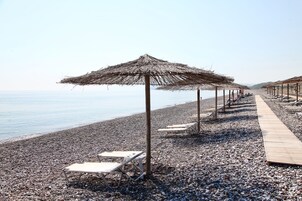 Uma praia privada, espreguiçadeiras, guarda-sóis de praia 
