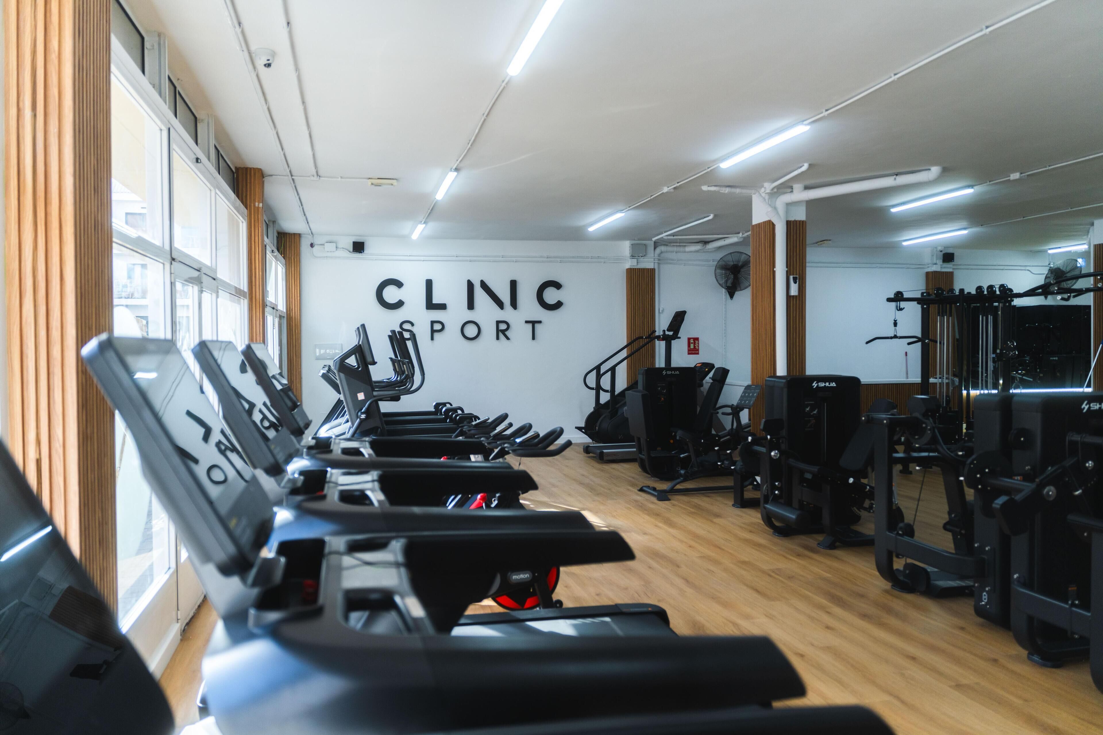 Academia com esteiras, elípticos e máquinas de musculação.