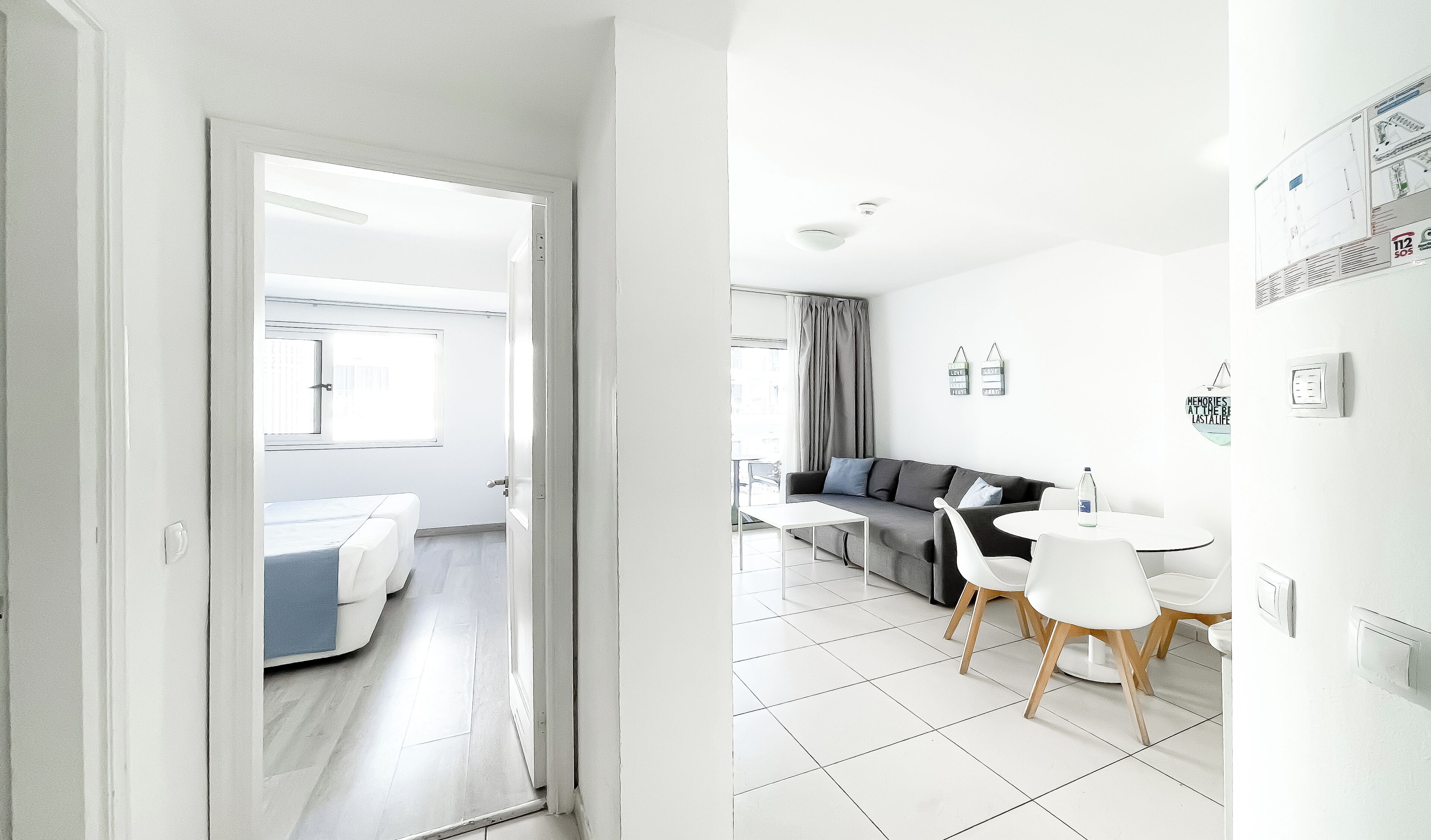 Um apartamento moderno e bem iluminado, com sala de estar, área de jantar e quarto.