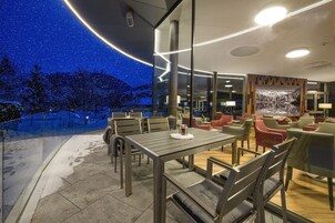 Restaurante com vista para uma paisagem nevada e um céu estrelado.