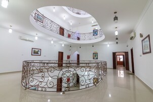 Um hall amplo com um balcão curvo, piso lustroso e design moderno no teto.