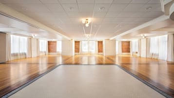 Quarto espaçoso com piso de madeira, azulejos hexagonais brancos e parede de tijolos.