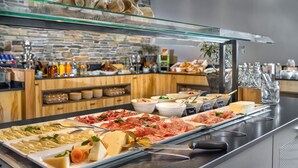 Buffet com diversos alimentos e um fundo de parede de pedra.